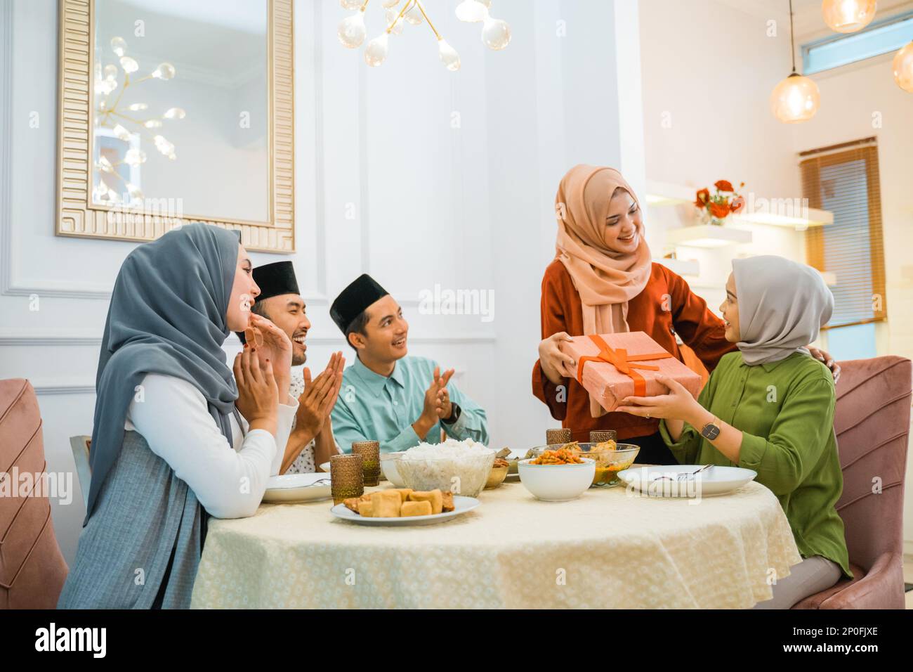 friends clap happily when one of their friends is rewarded Stock Photo ...