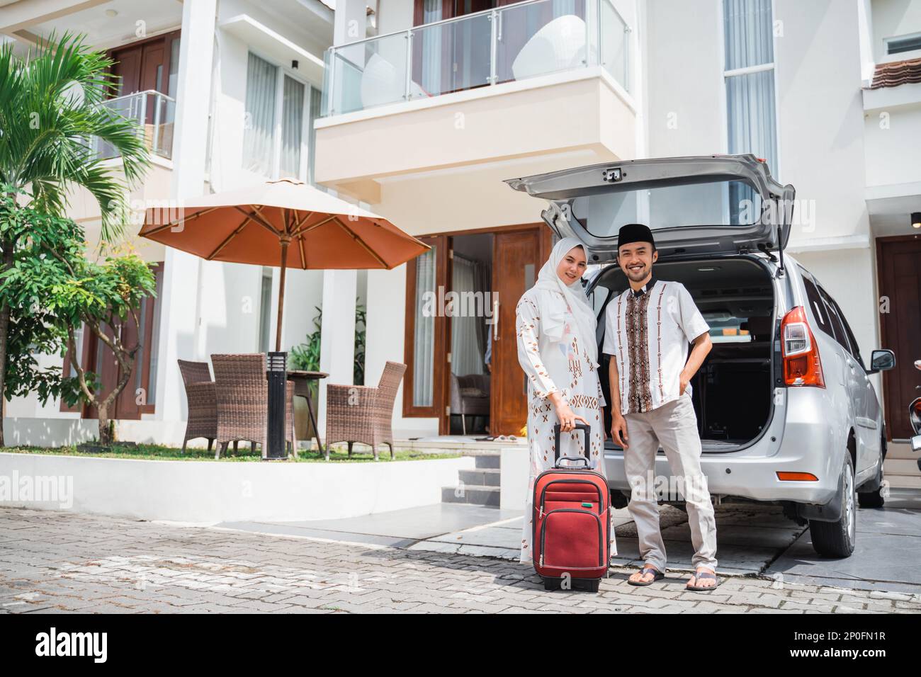 Muslim couple standing behind the trunk of car holding suitcases Stock ...