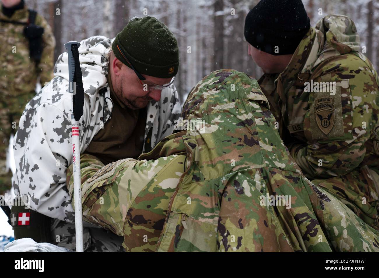 A Finnish Soldier assigned to Jaeger Brigade, assists a U.S. Army ...