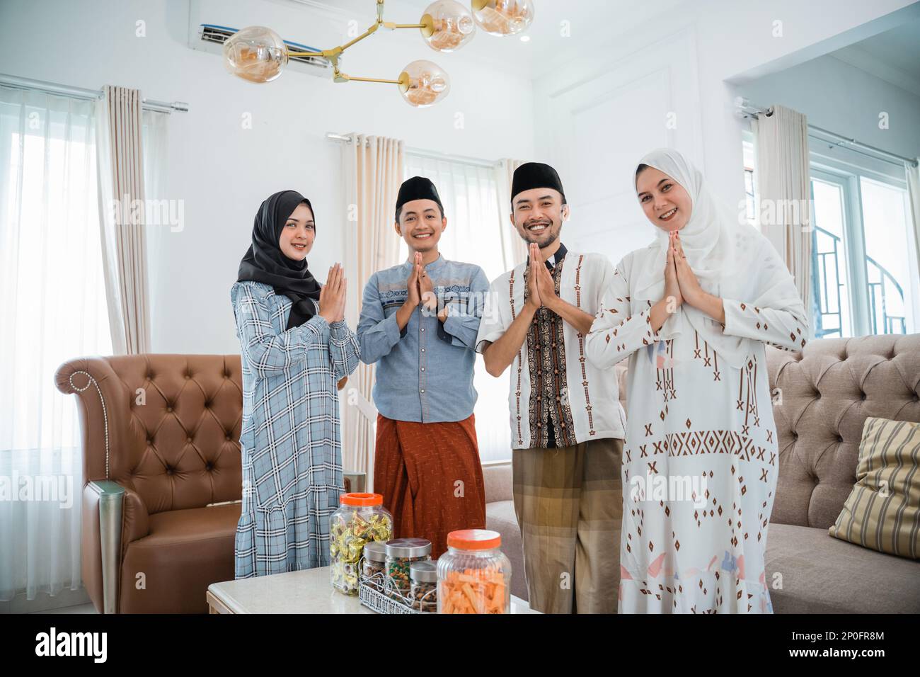 two smiling muslim couple with apologetic hand gestures to camera Stock ...