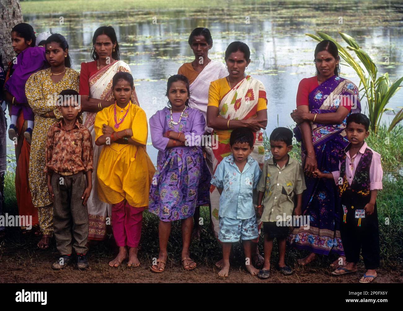 Spectators during boat race standing under the tree shades in the River ...