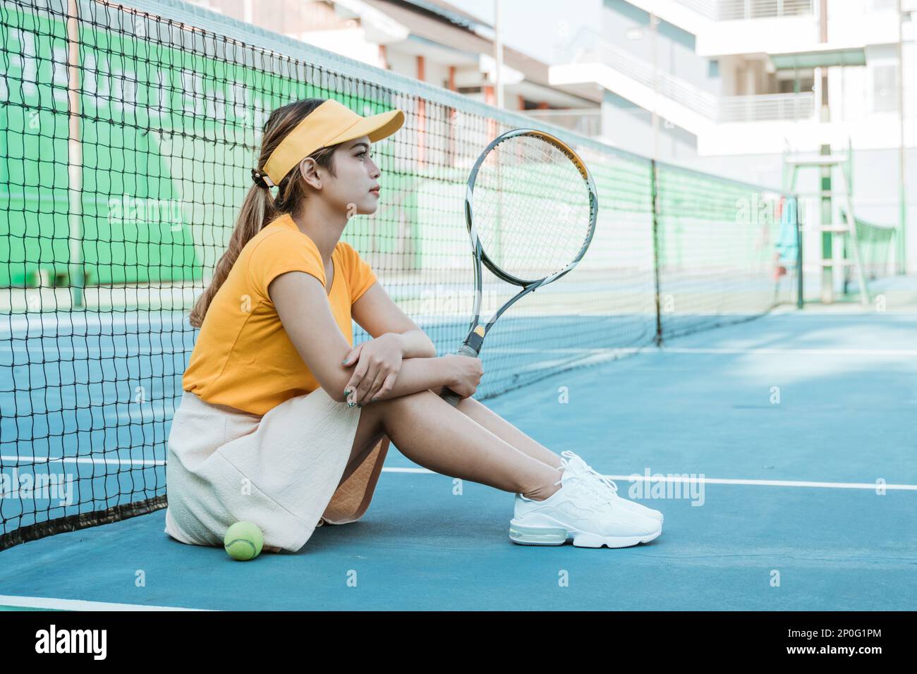 asian female tennis player sitting holding racket on tennis court Stock ...