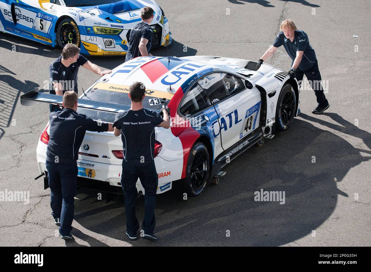 Race car BMW M6 GT3, mechanics pushing car, technical check before race ...