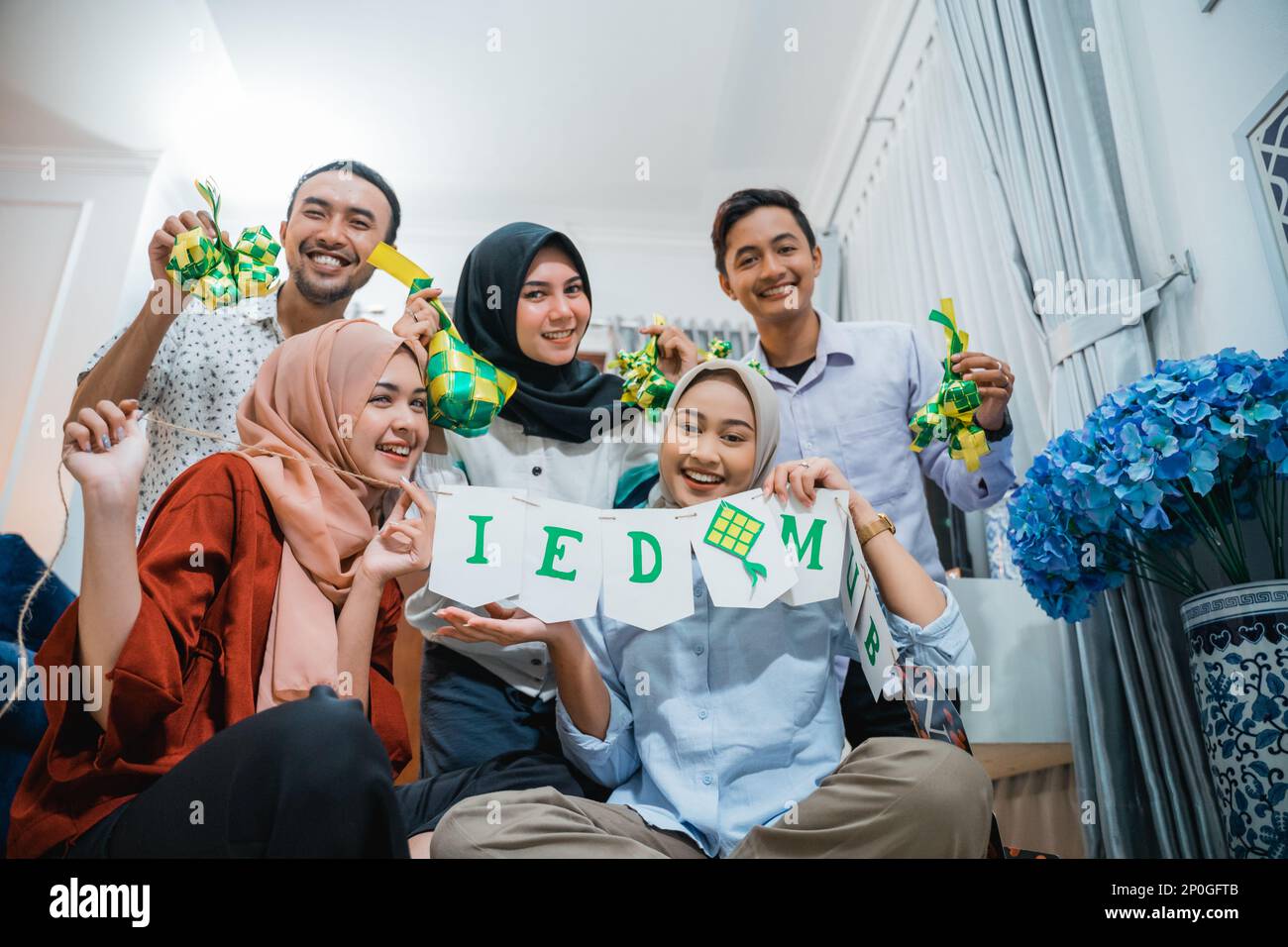 friends show flag chains and ketupat ornaments for Eid celebration ...