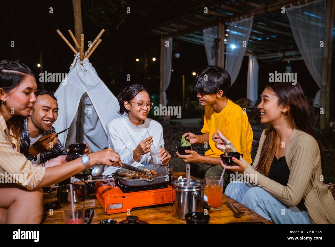 a group of people hangout together and grilling the beef hapily Stock ...