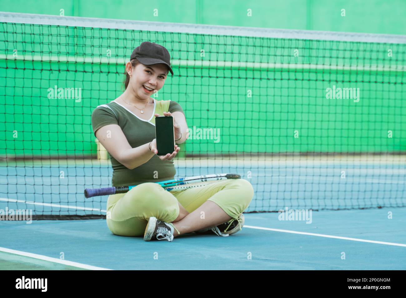 female tennis player showing mobile phone screen to camera Stock Photo ...