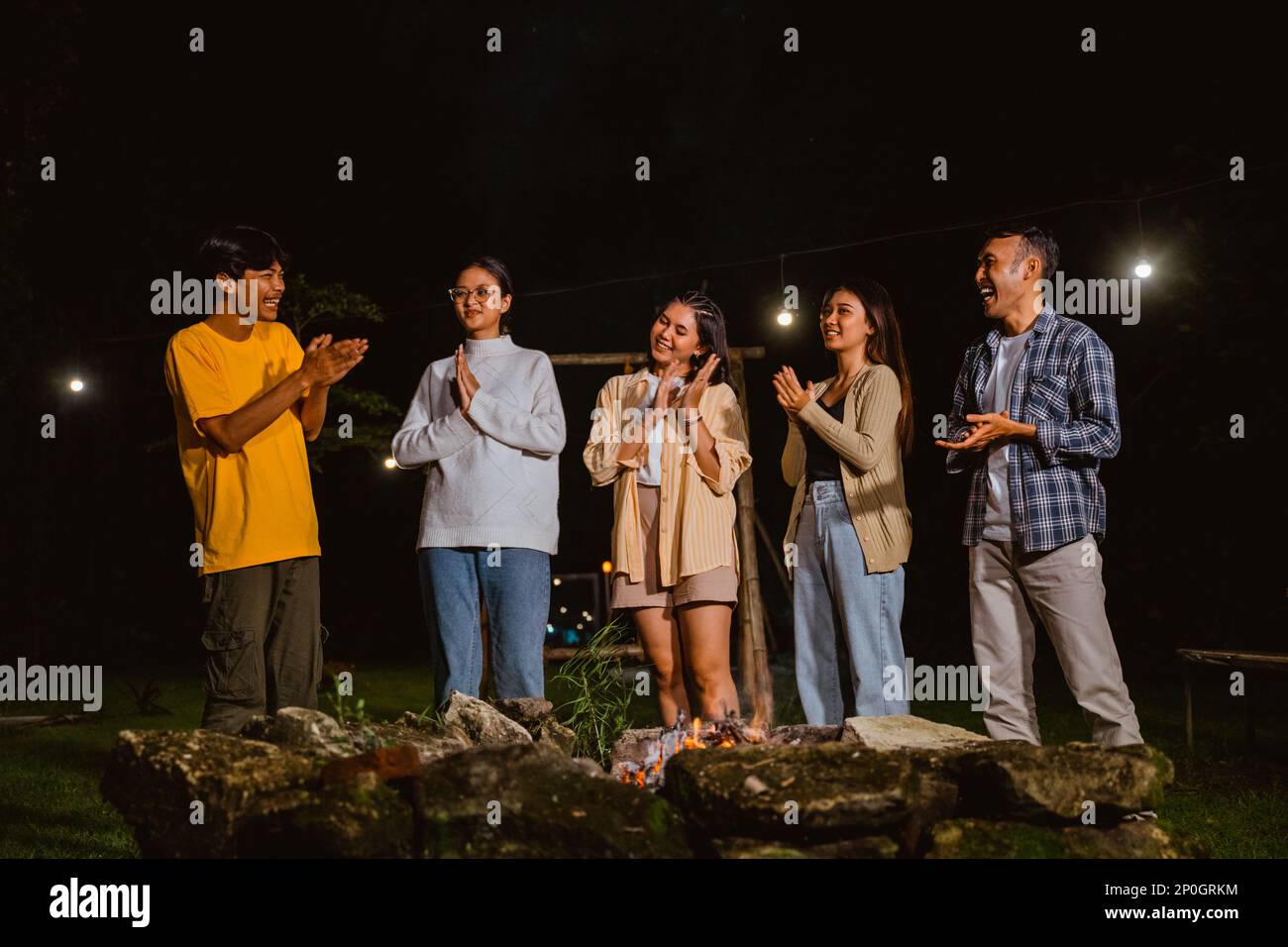 a group of people clap their hands while standing in circle Stock Photo ...