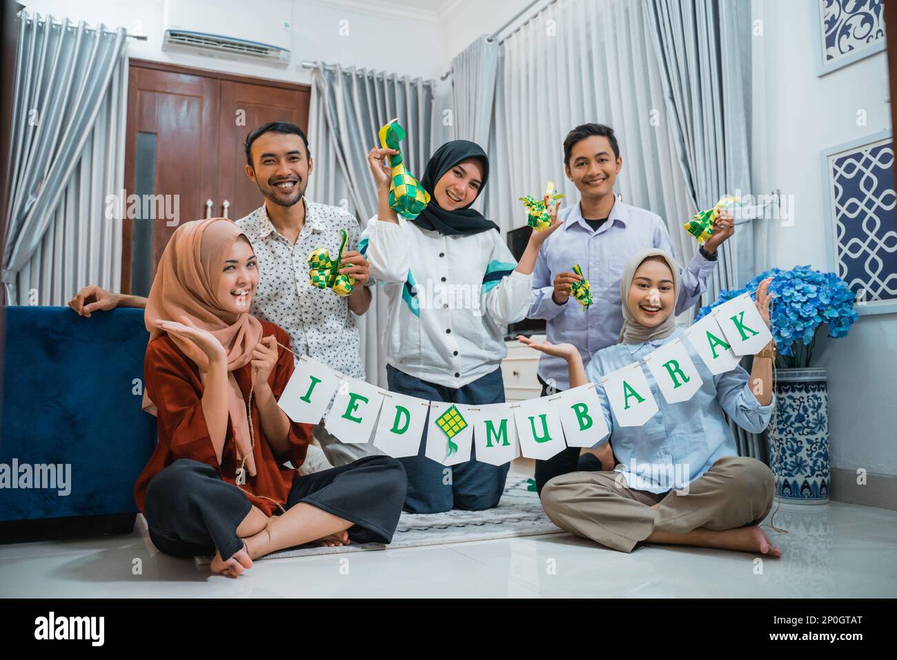 five smiling Muslims holding flag chains and eid mubarak decorations ...