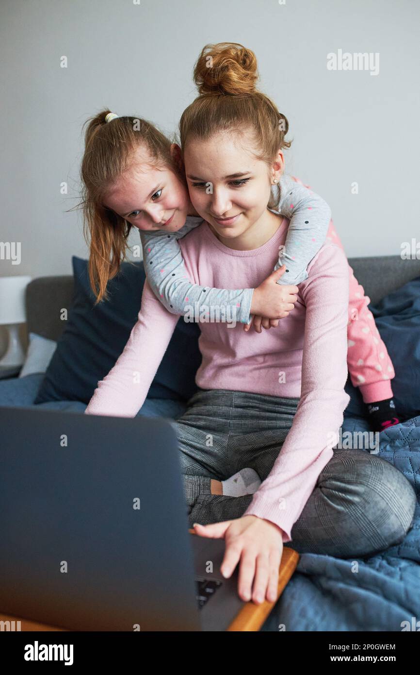 Grandchildren teenage girl and her younger sister talking on video call ...