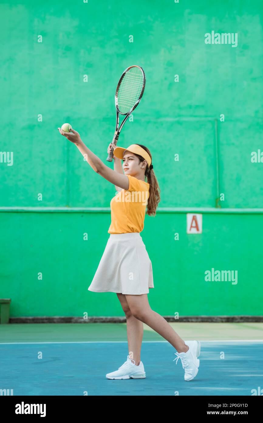 female tennis player serving the ball with a racket Stock Photo - Alamy