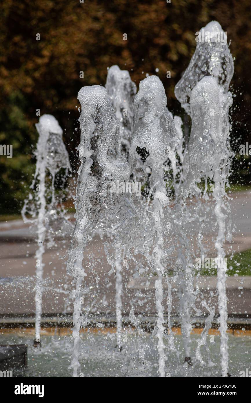 Close up outdoor view in the night of a public fountain with many small ...