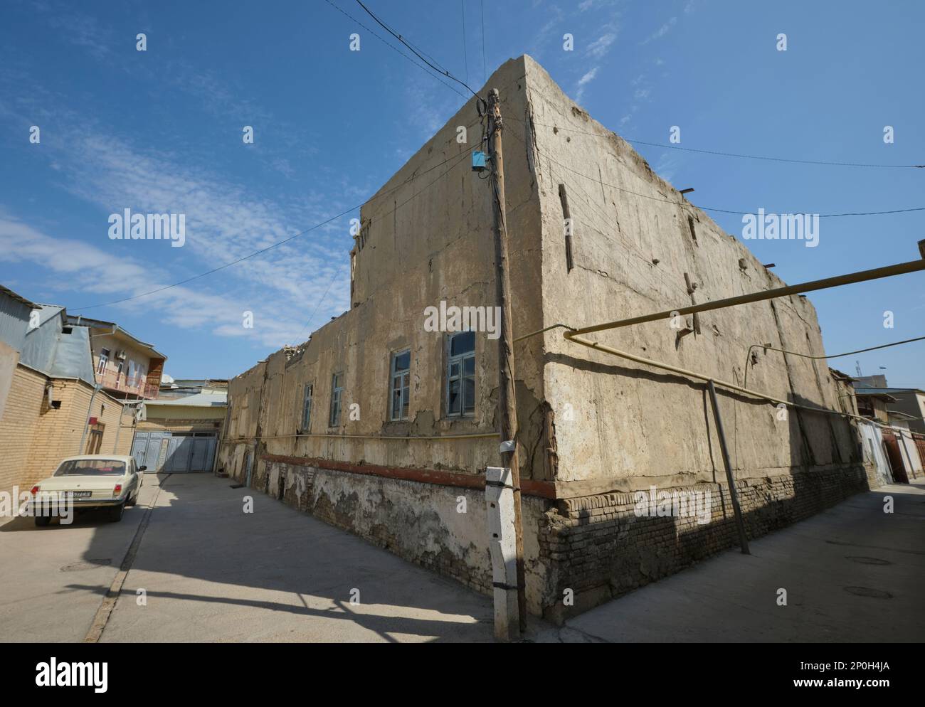 Unassuming, plain exterior of a house, now in ruin. At an old, historic ...