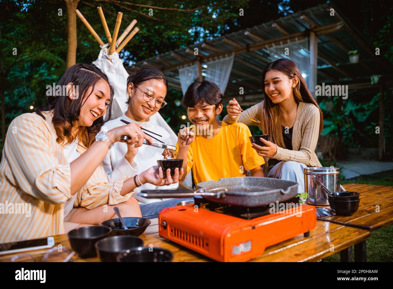 the group of people eating grilled beef together Stock Photo - Alamy