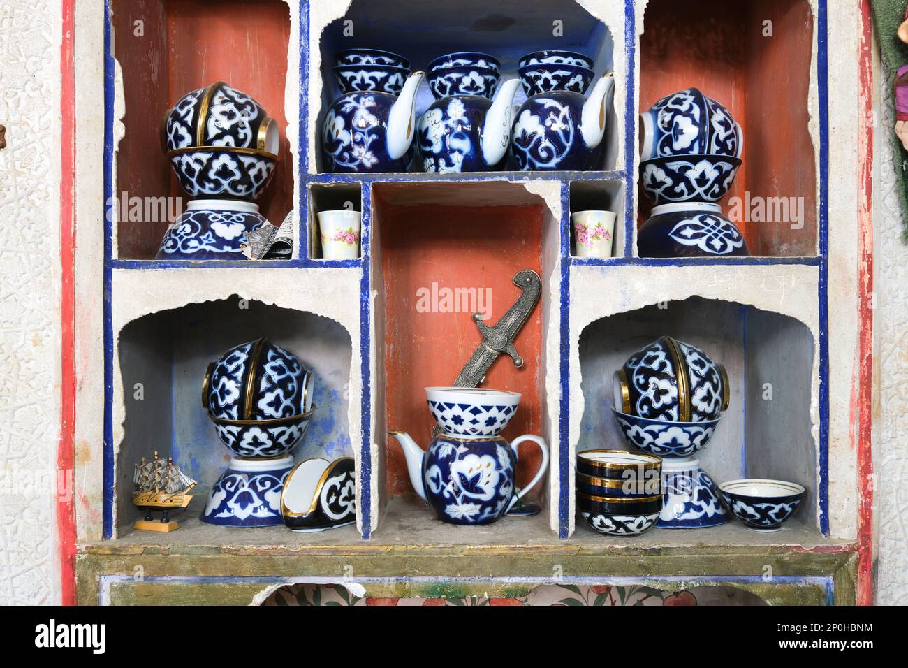 Detail of family dishes, china, art, items in the cutout, casework. A ...