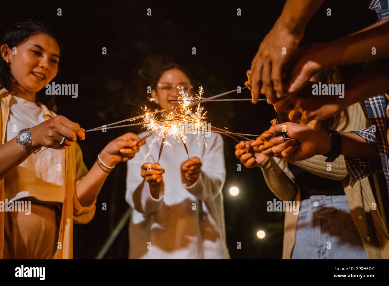 a group of people standing and put their fireworks together Stock Photo ...