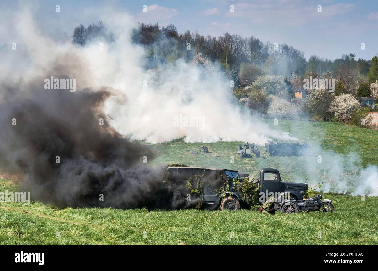 German military trucks, troops, under fire, at reenactment of WW2 ...