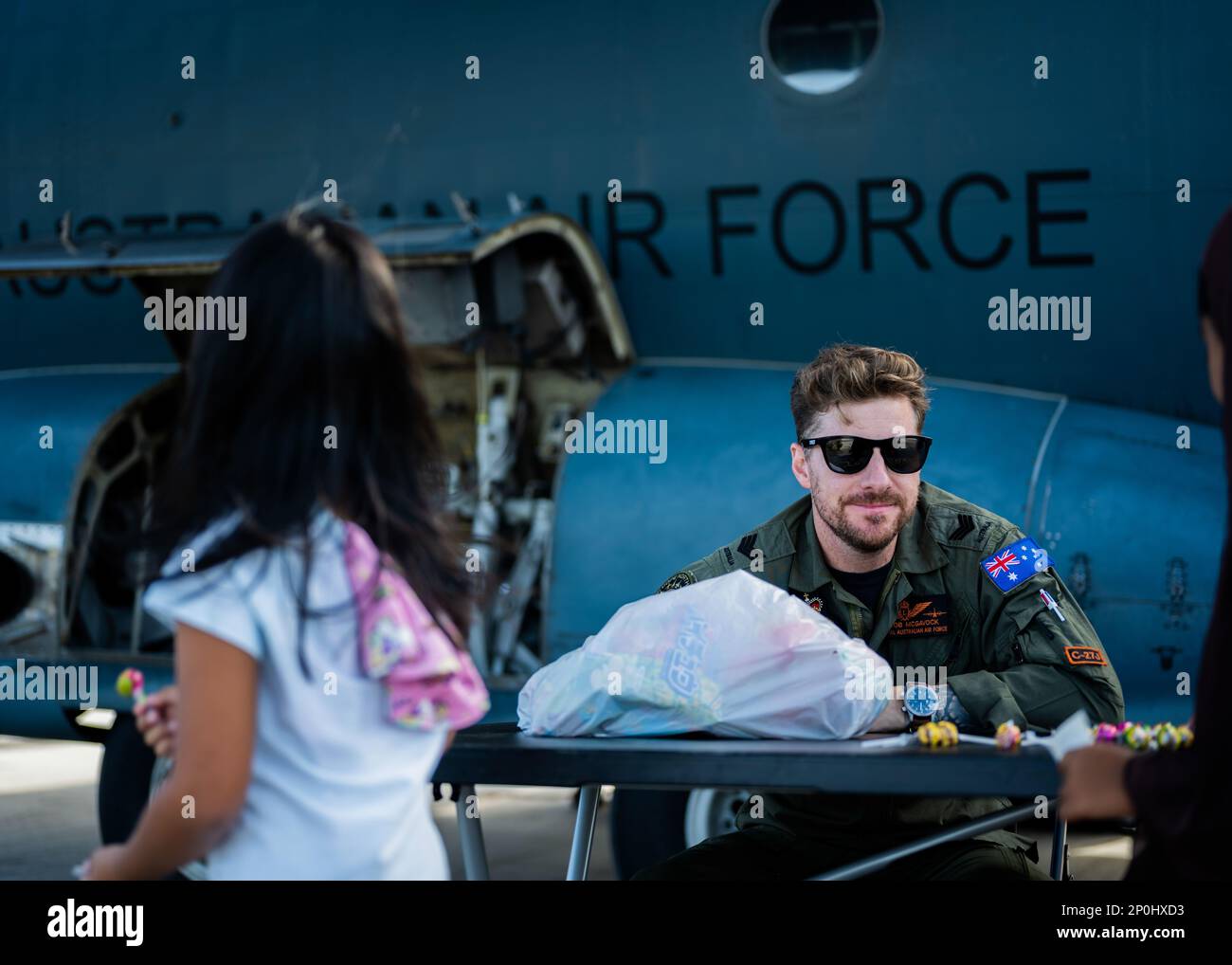 Royal Australian Air Force Sergeant Robert McGavock, C-27 Spartan loadmaster, passes out candy ...