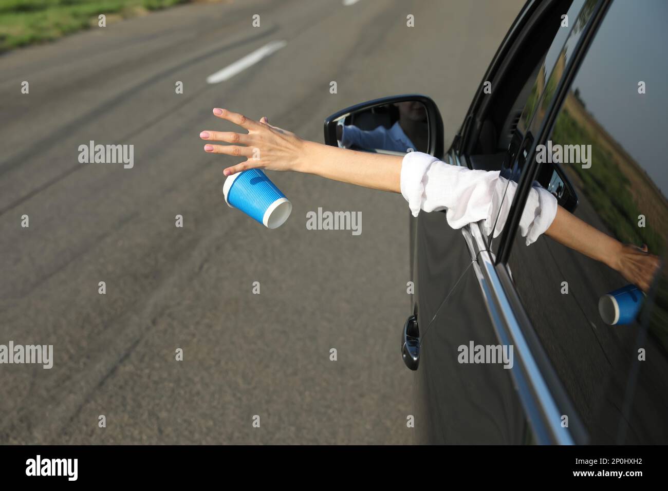 Driver throwing away paper cup from car window. Garbage on road Stock ...