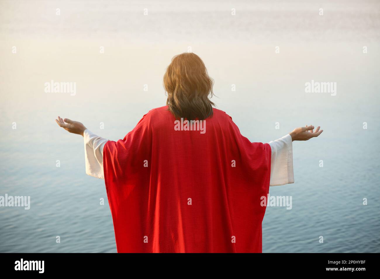 Jesus Christ near water outdoors, back view Stock Photo - Alamy