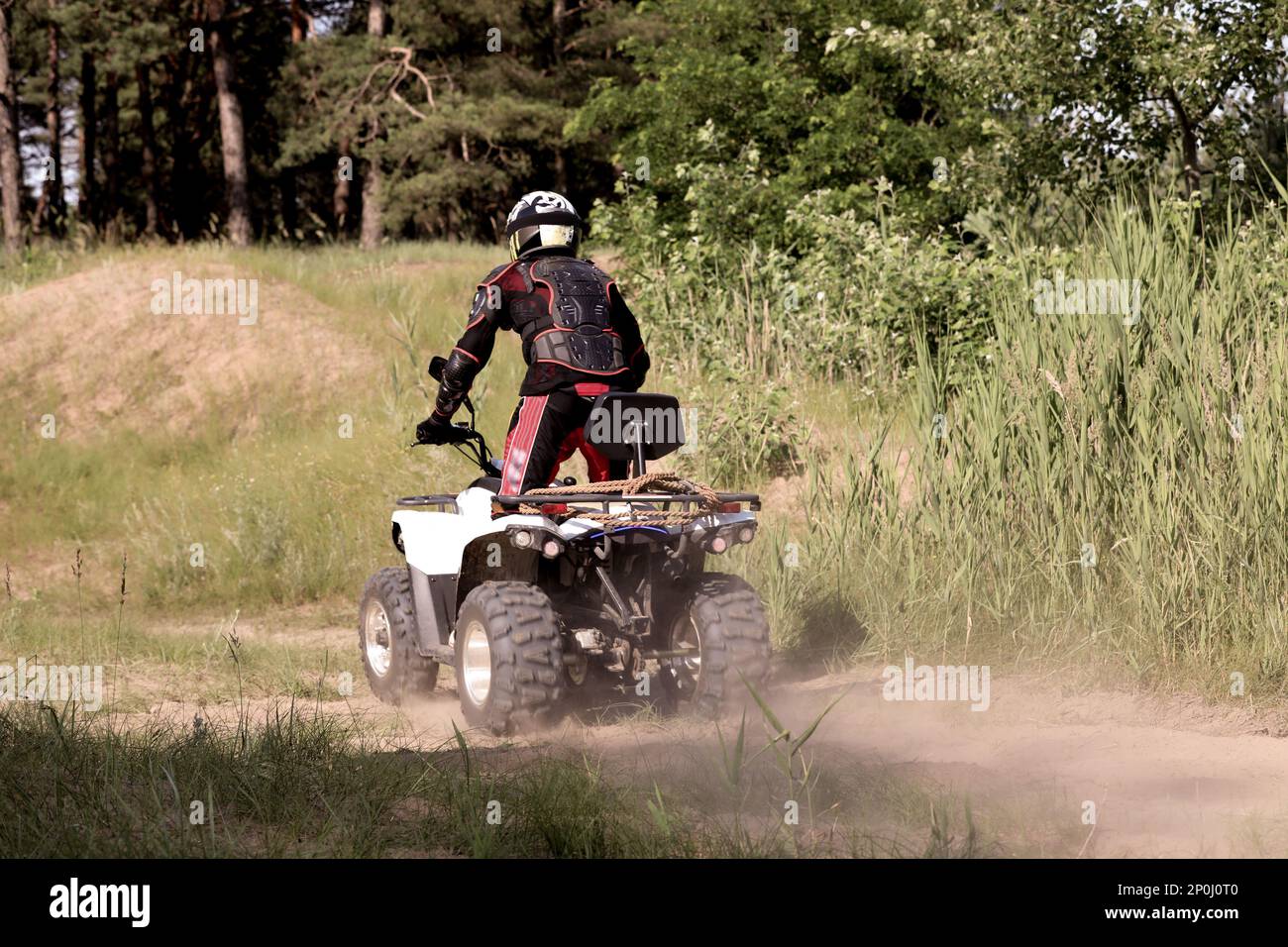 Man driving modern quad bike on sandy road, back view. Extreme sport ...