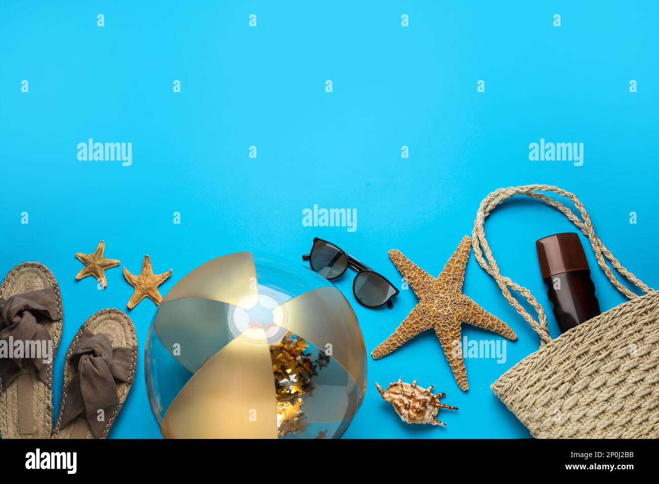 Flat lay composition with ball and beach objects on light blue ...