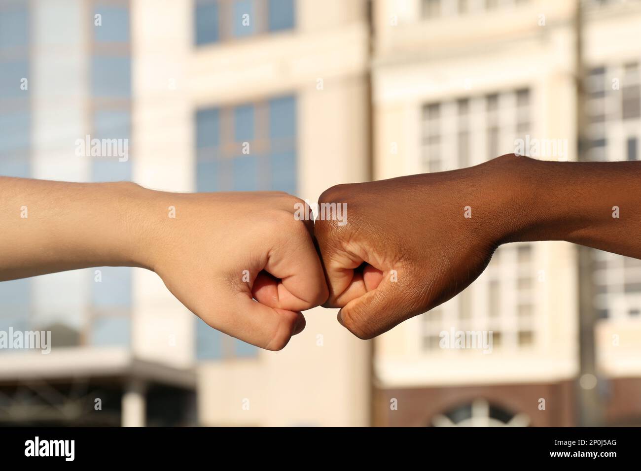 Men making fist bump on city street, closeup Stock Photo - Alamy