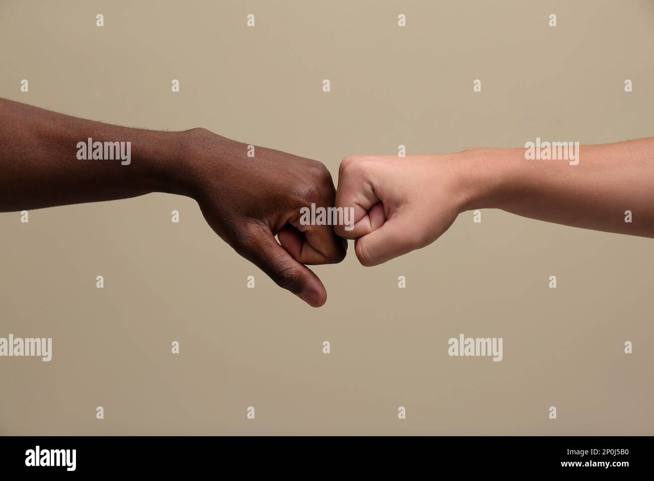 Men making fist bump on beige background, closeup Stock Photo - Alamy