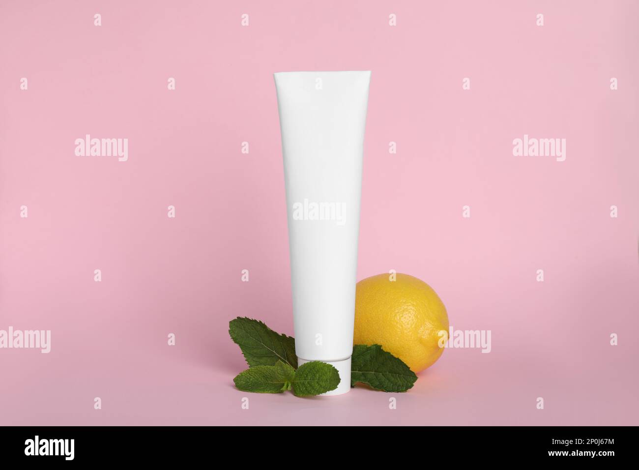 Blank tube of toothpaste, fresh mint and lemon on pink background Stock ...