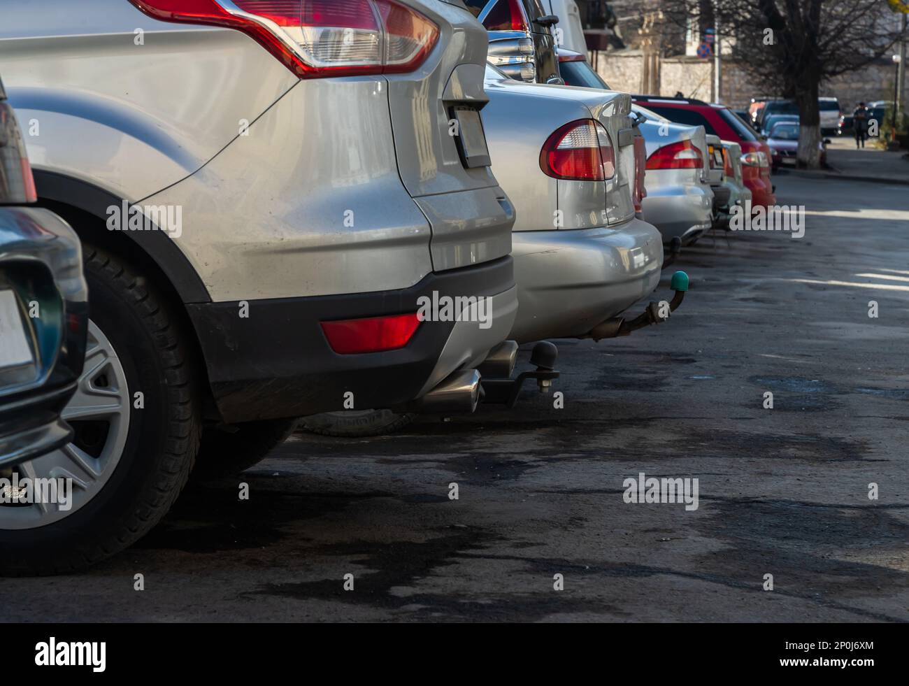 Closeup of rear, back side of golden car with other cars parking in ...