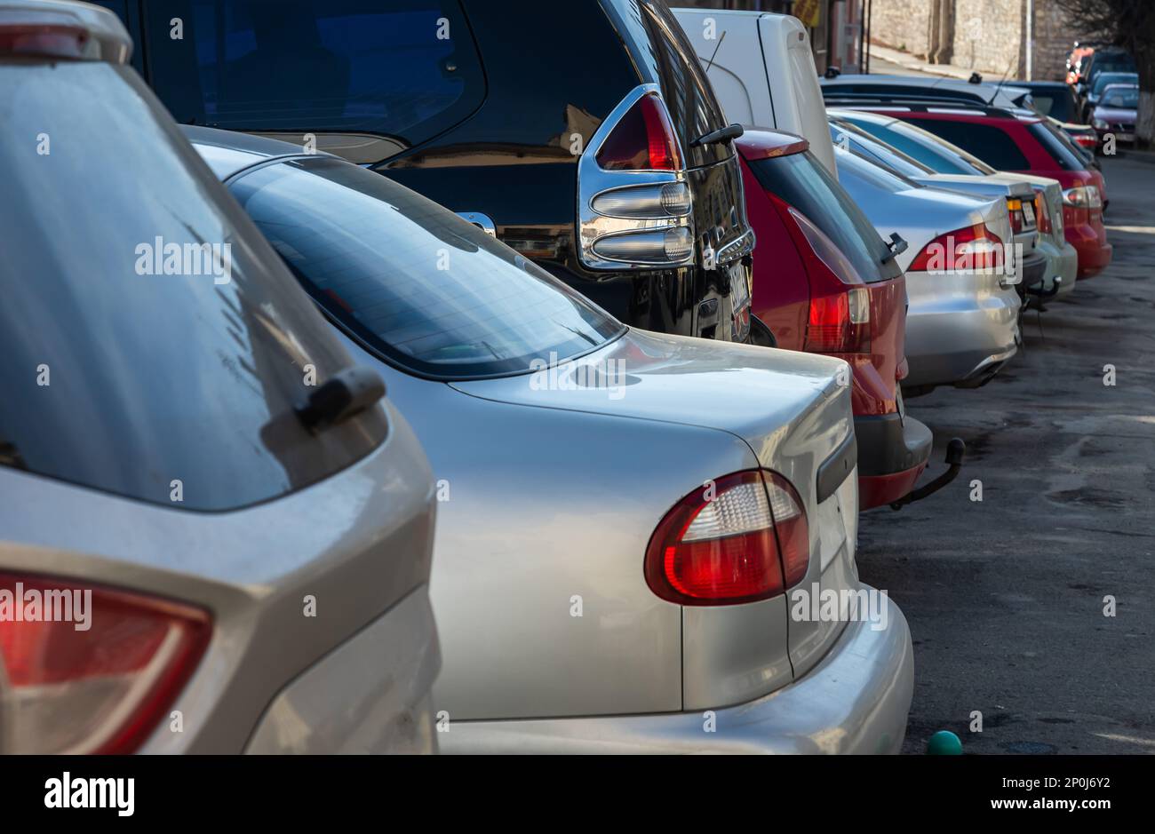 Closeup of rear, back side of golden car with other cars parking in ...