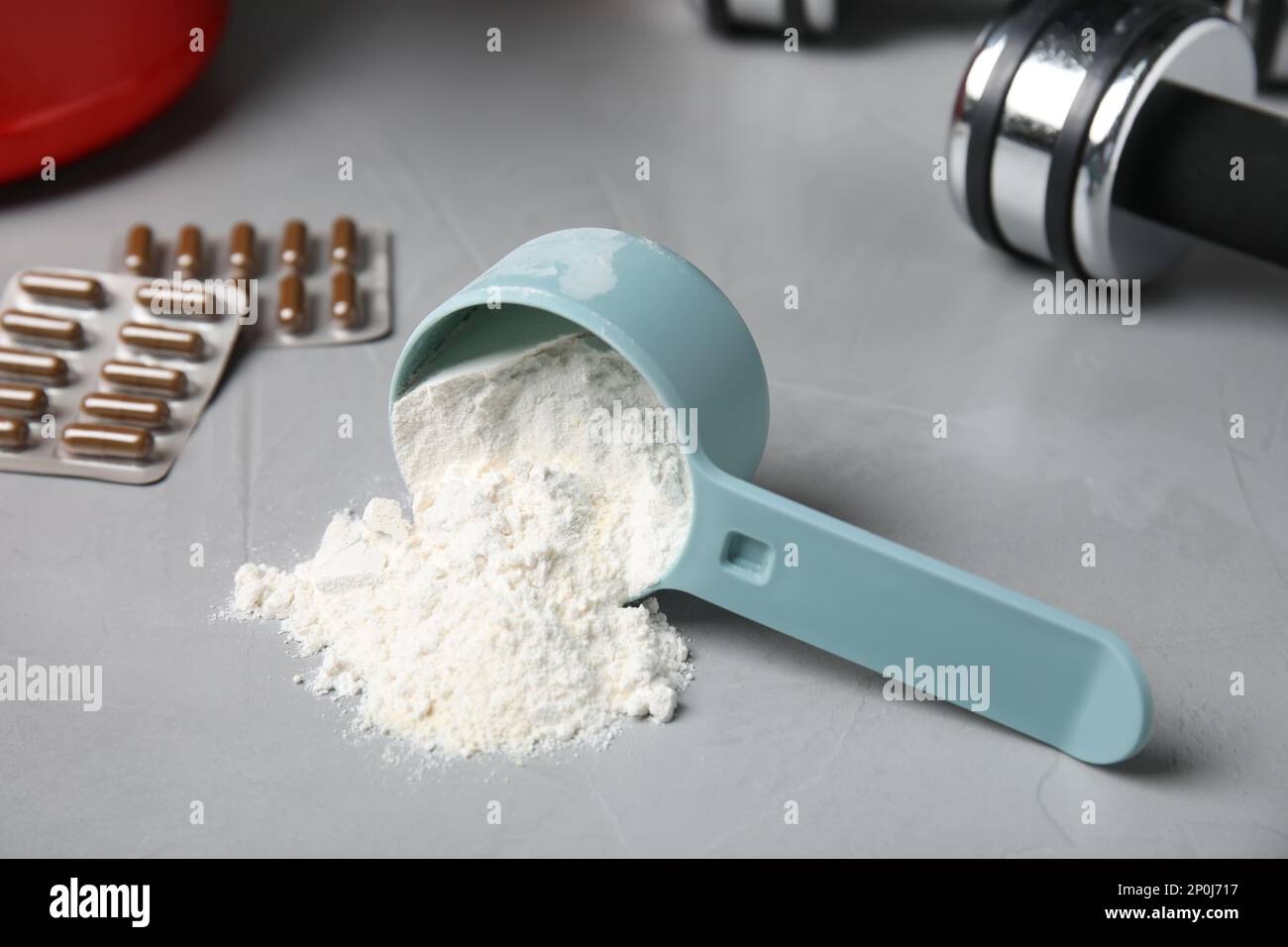 Measuring scoop of amino acids powder on light grey table Stock Photo ...