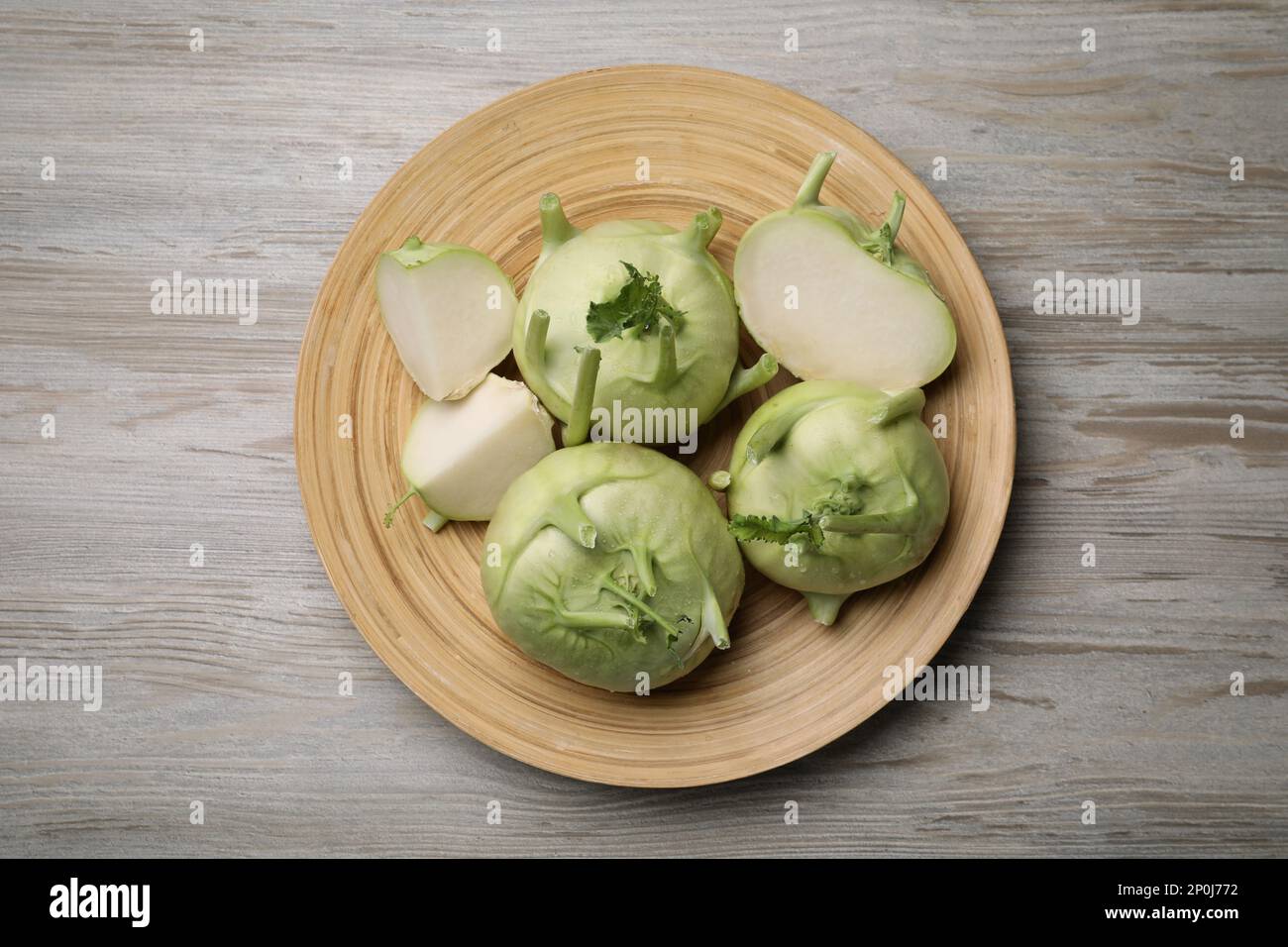 Whole and cut kohlrabi plants on wooden table, top view Stock Photo - Alamy