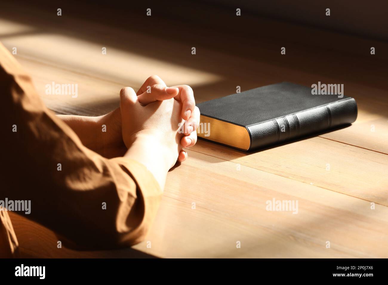 Religious woman praying over Bible indoors, closeup Stock Photo - Alamy