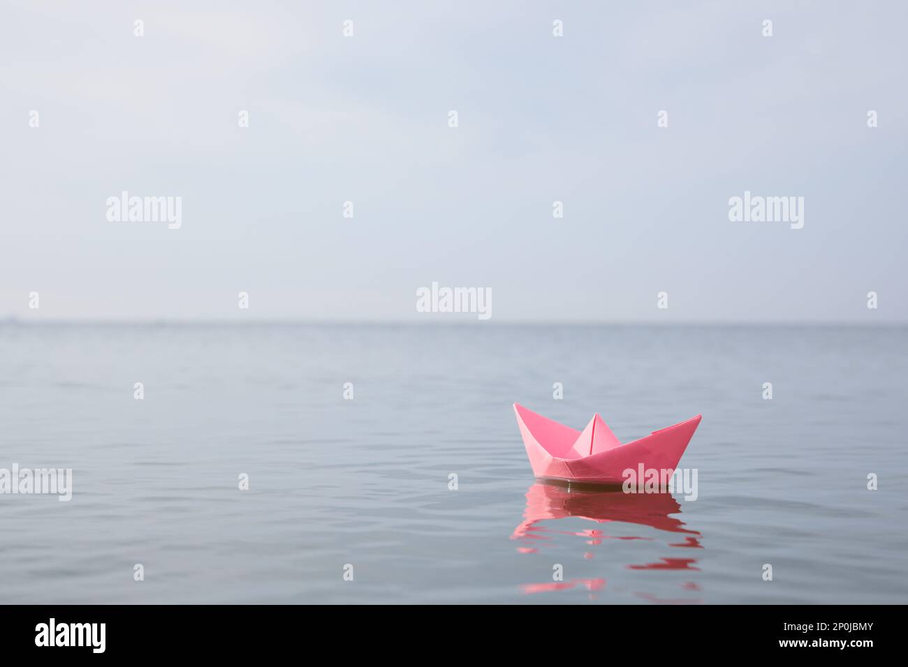 Pink paper boat on water surface, space for text Stock Photo - Alamy