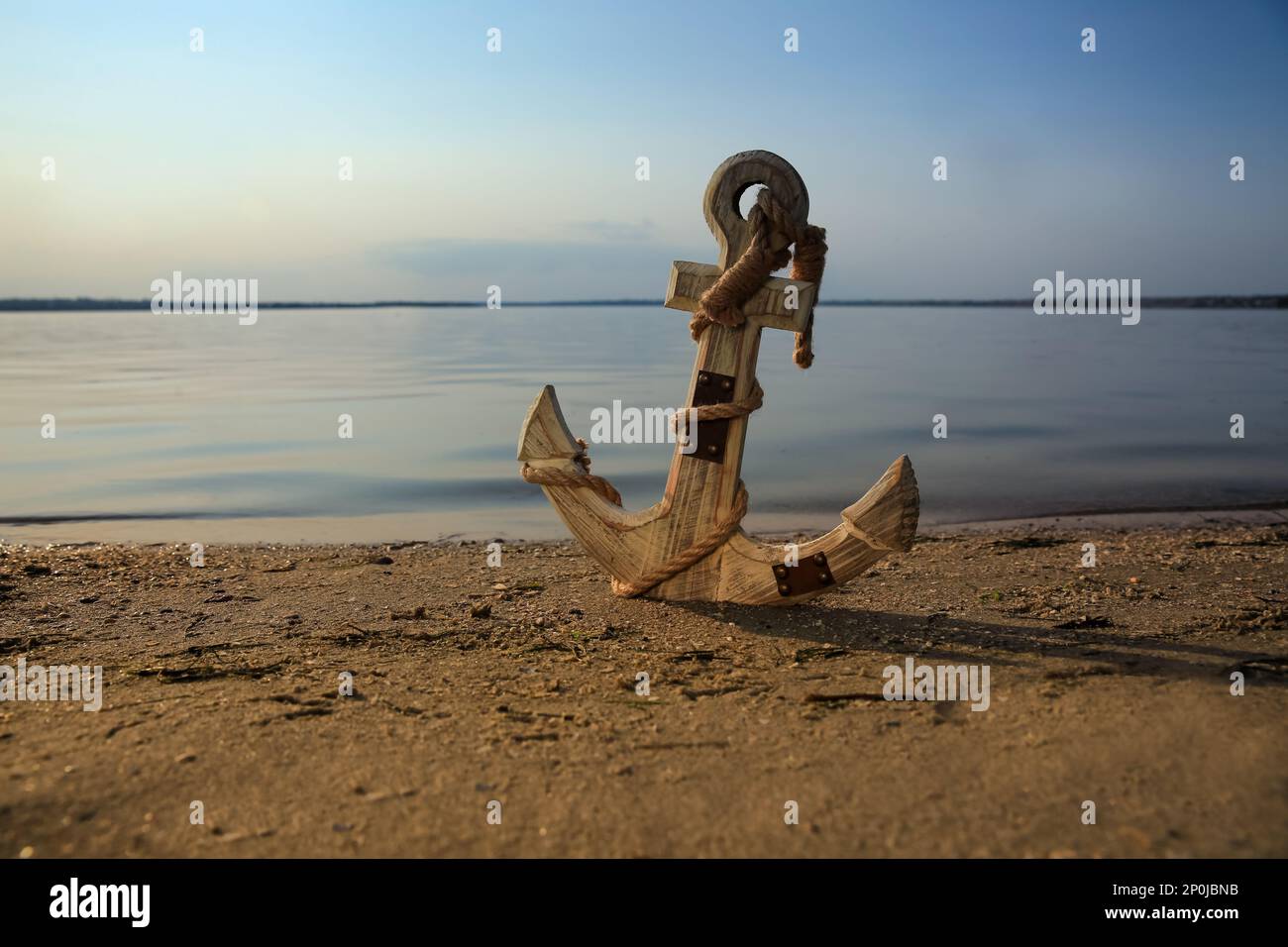 Wooden anchor on river shore near water Stock Photo - Alamy
