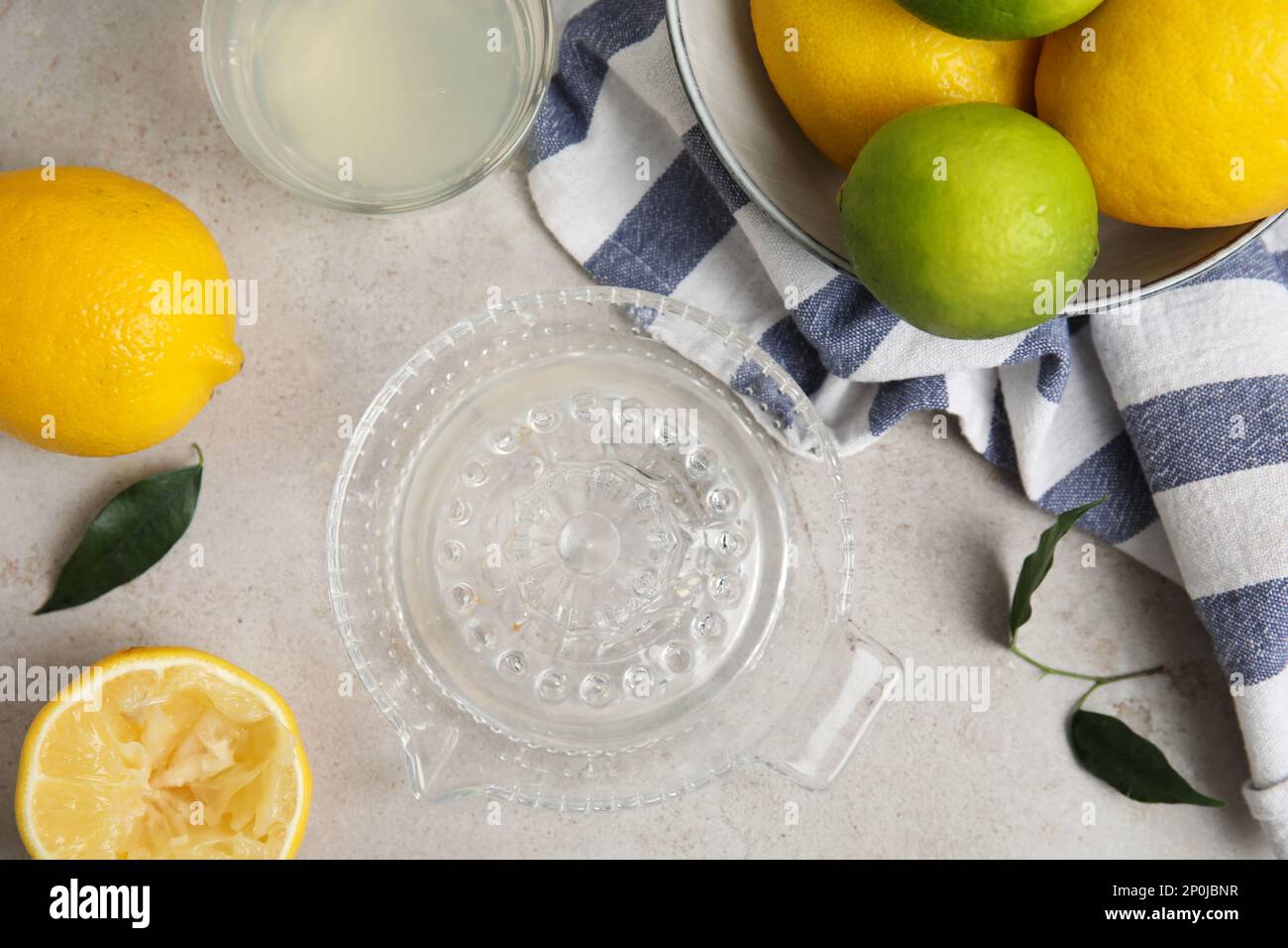Glass squeezer with juice and lemons on light table, flat lay Stock ...