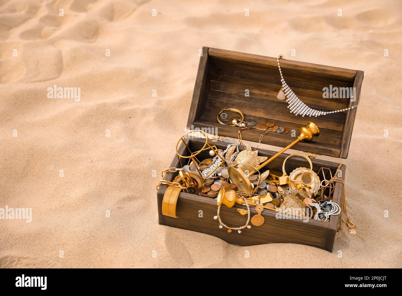 Open wooden treasure chest on sand, space for text Stock Photo - Alamy