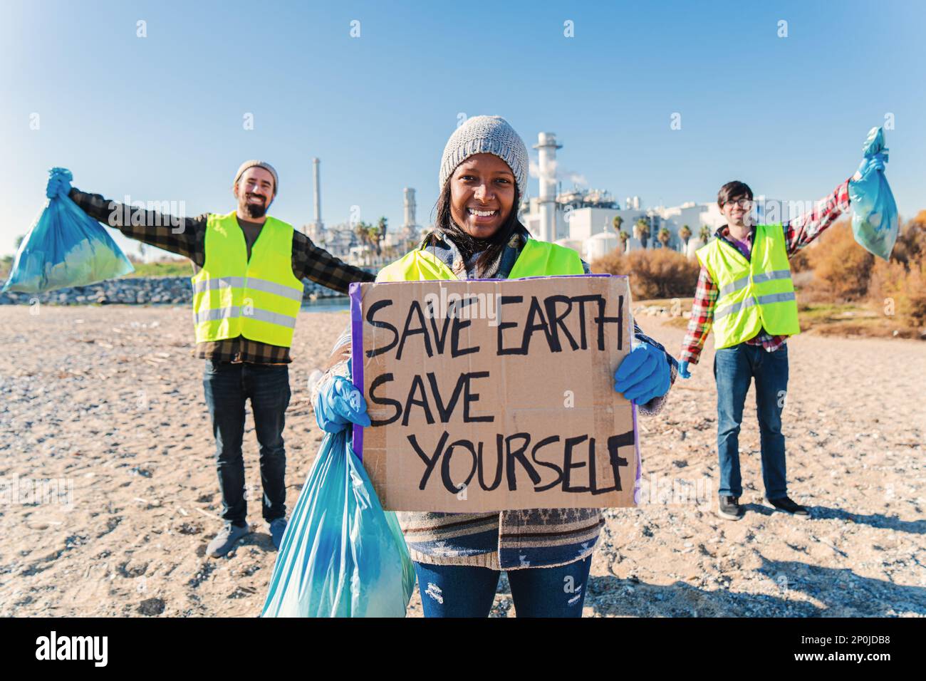 On foreground one happy environmental volunteer smiling and holding a ...