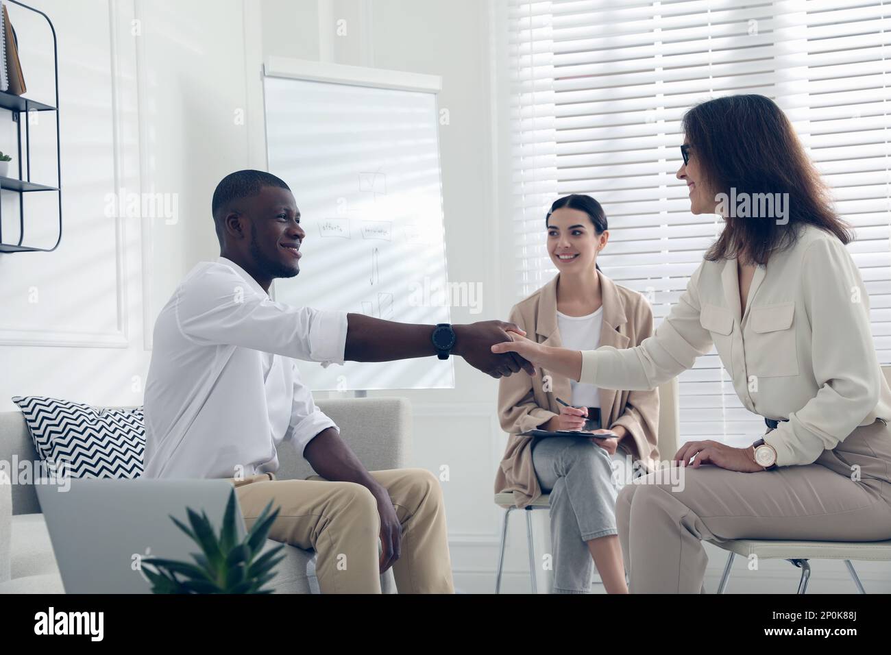 Boss shaking hands with new coworker during job interview in office ...