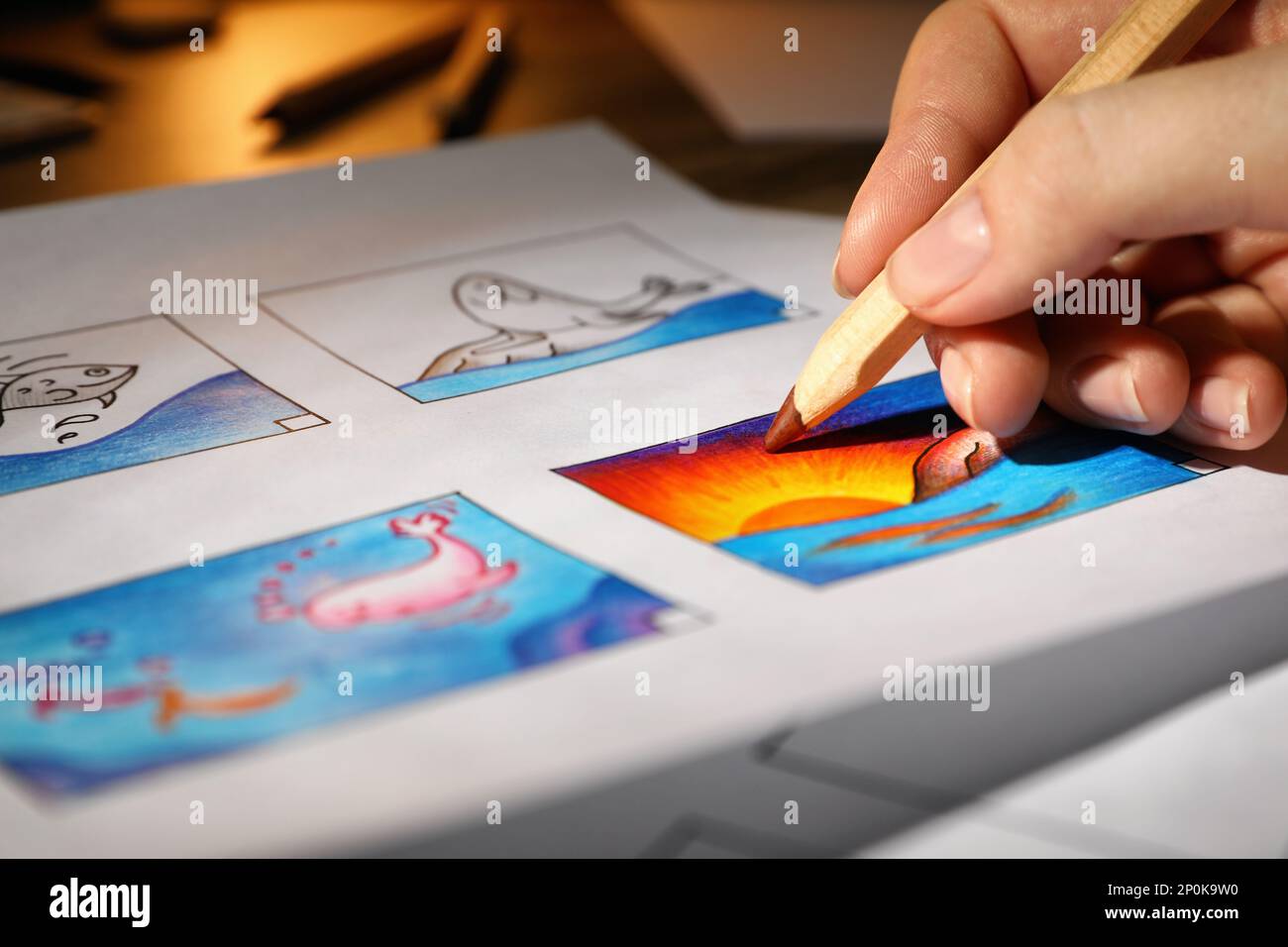 Woman drawing cartoon sketch in storyboard at workplace, closeup. Pre ...