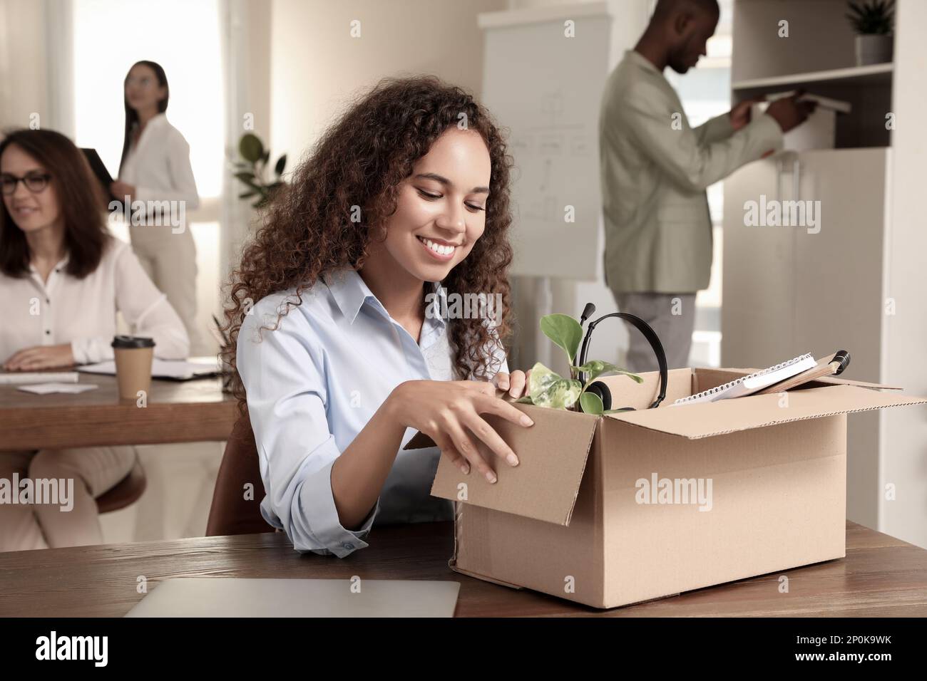 New coworker unpacking box with personal items at workplace in office ...