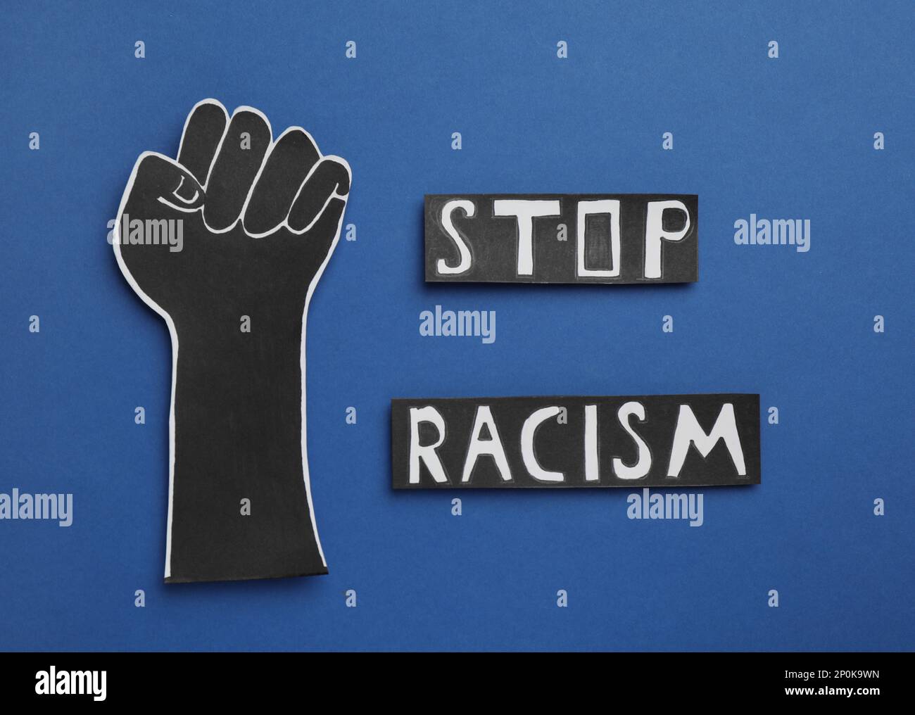 Words Stop Racism near paper hand with clenched fist on blue background ...
