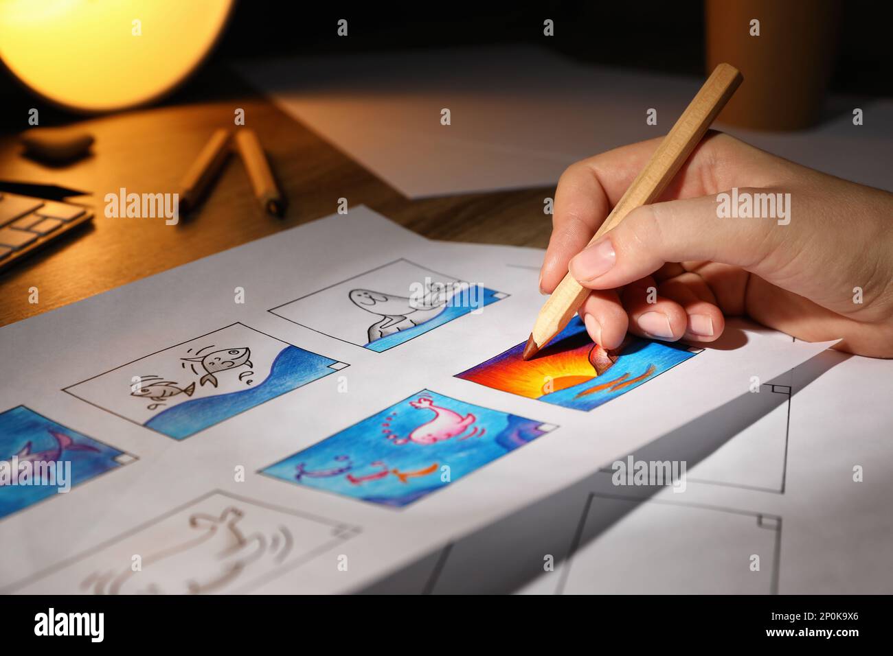 Woman drawing cartoon sketch in storyboard at workplace, closeup. Pre ...