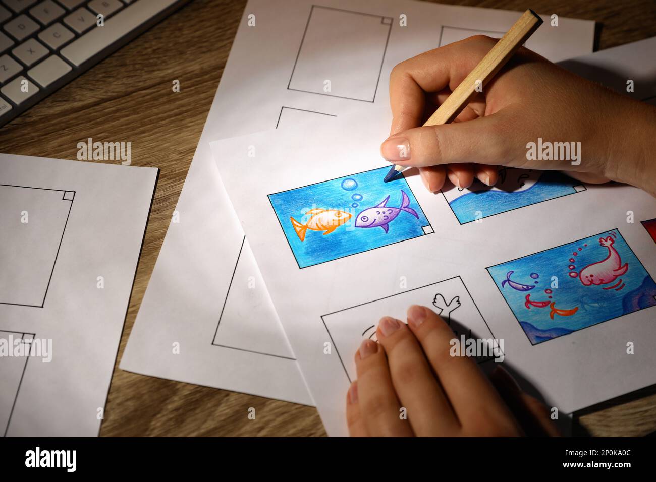 Woman drawing cartoon sketch in storyboard at workplace, closeup. Pre ...