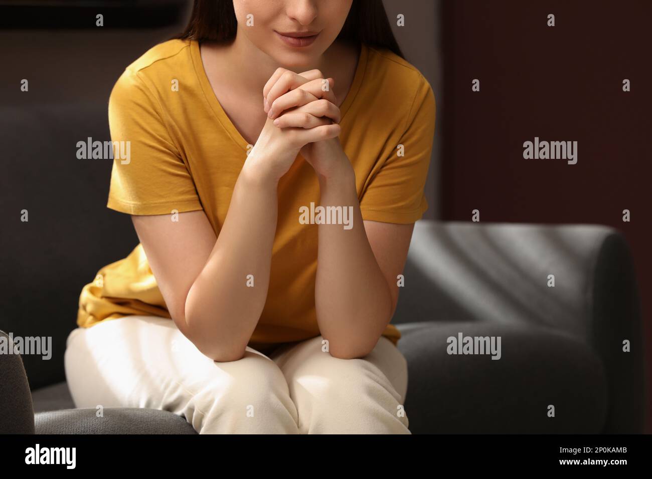 Religious woman with clasped hands praying indoors, closeup Stock Photo ...