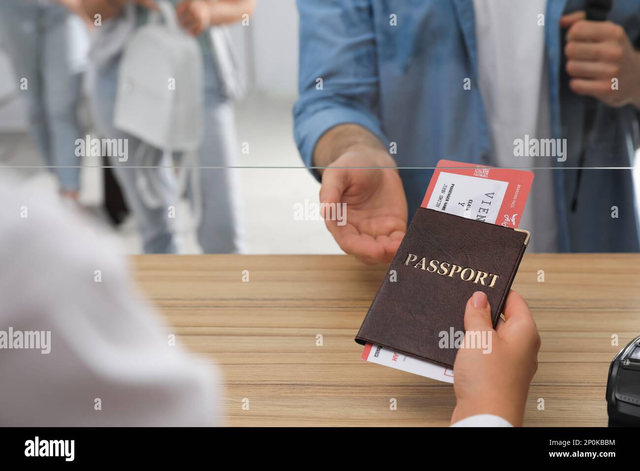 Agent giving passport with ticket to client at check-in desk in airport ...