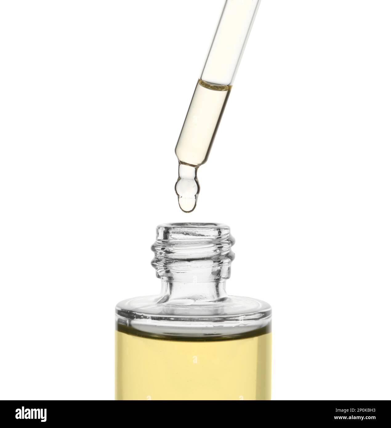 Dripping oil from pipette into glass bottle isolated on white, closeup ...