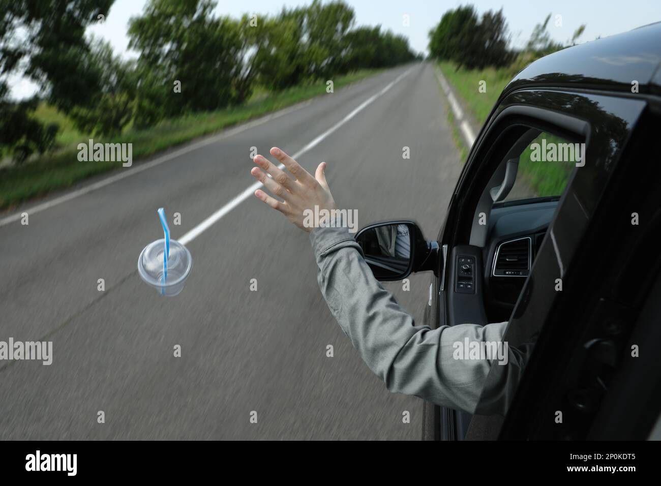 Driver throwing away plastic cup from car window. Garbage on road Stock ...