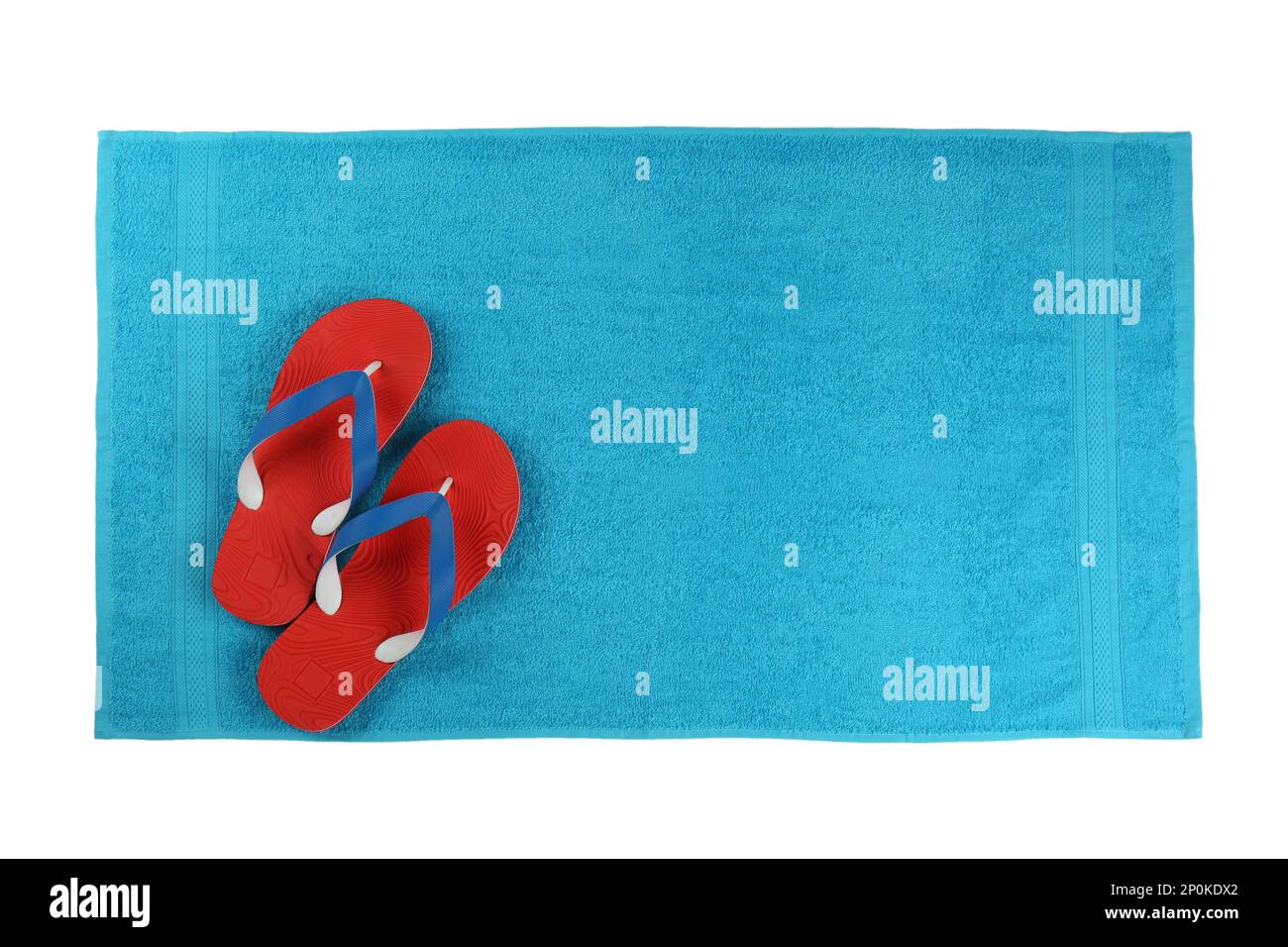 Clean light blue beach towel and flip flops on white background, top ...