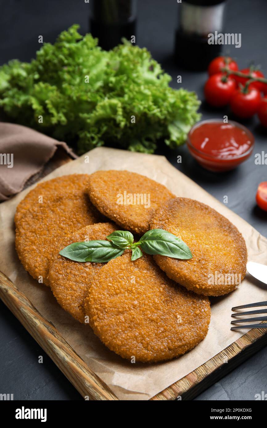 Delicious fried breaded cutlets served on black table, closeup Stock ...